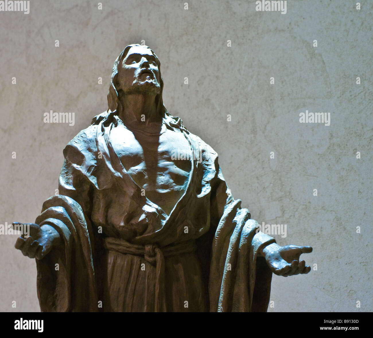 Bronze sculpture of a figure with outstretched hands, gazing upward in ...