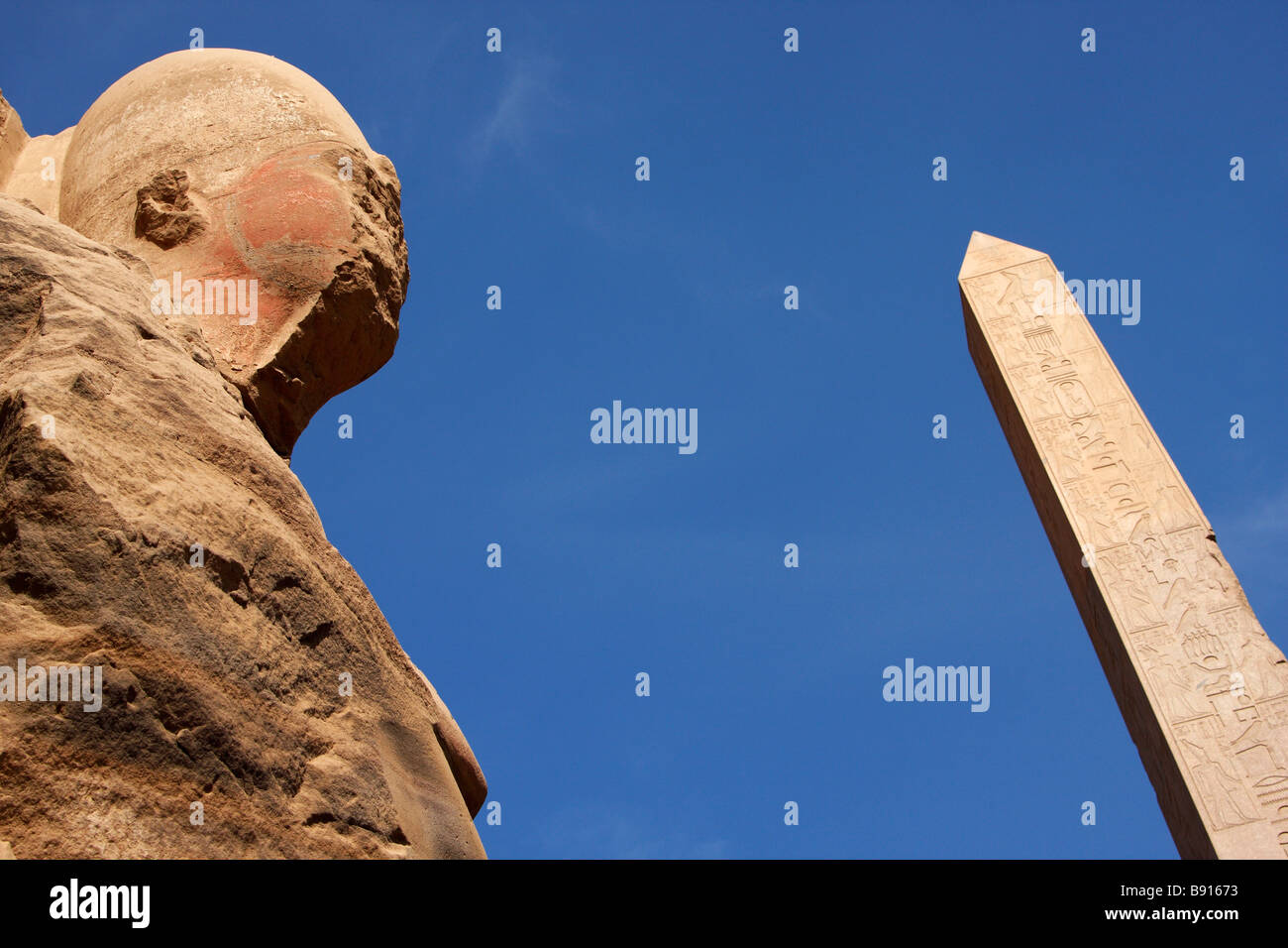 Head of colossal stone carved osiris statue and Obelisk of Queen ...