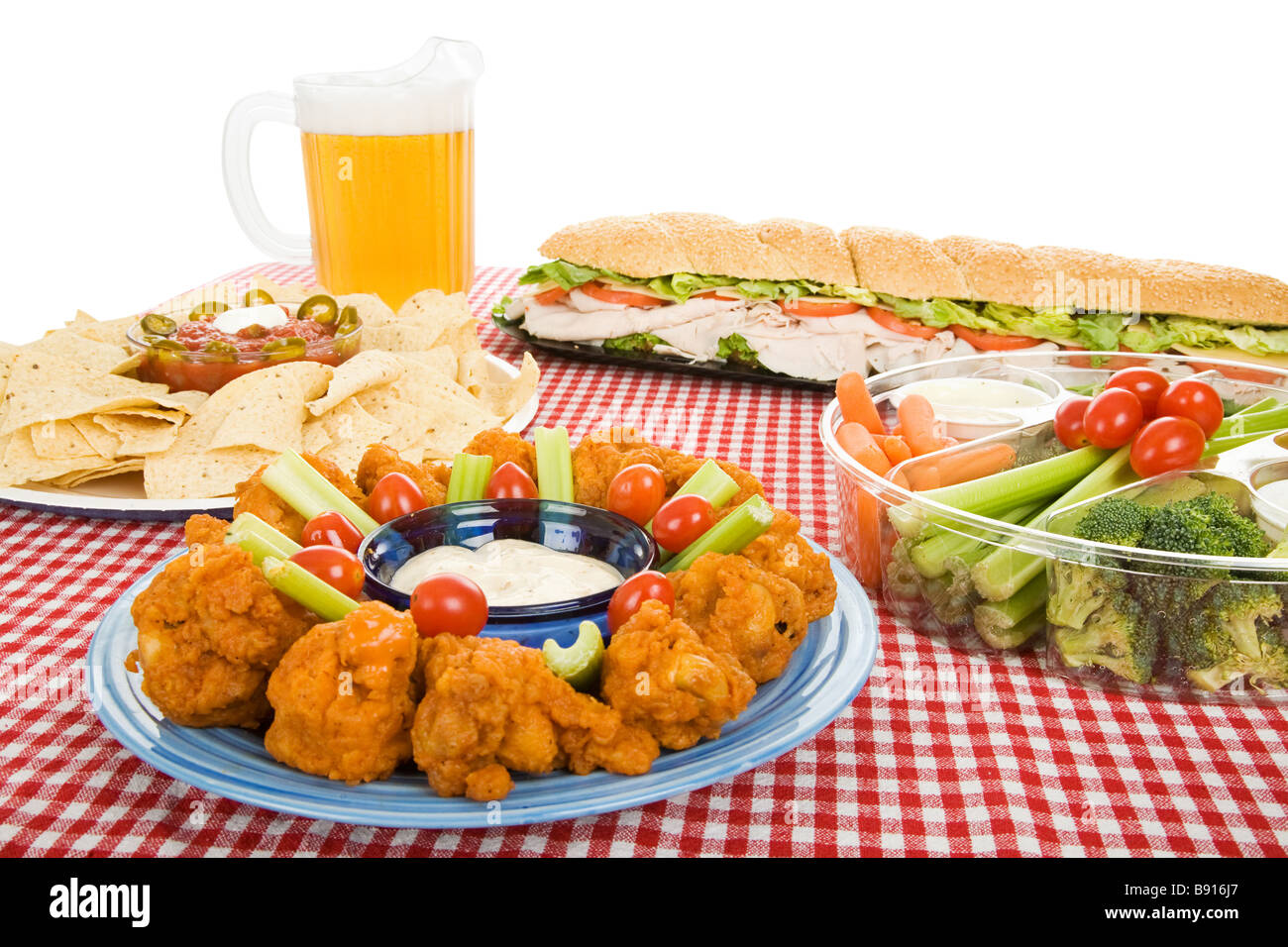 Table set with a variety of party foods and a pitcher of beer White ...