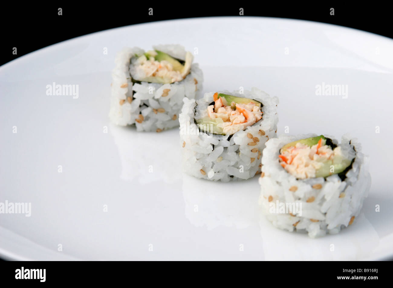 California roll diagonal on white plate with black background Stock ...