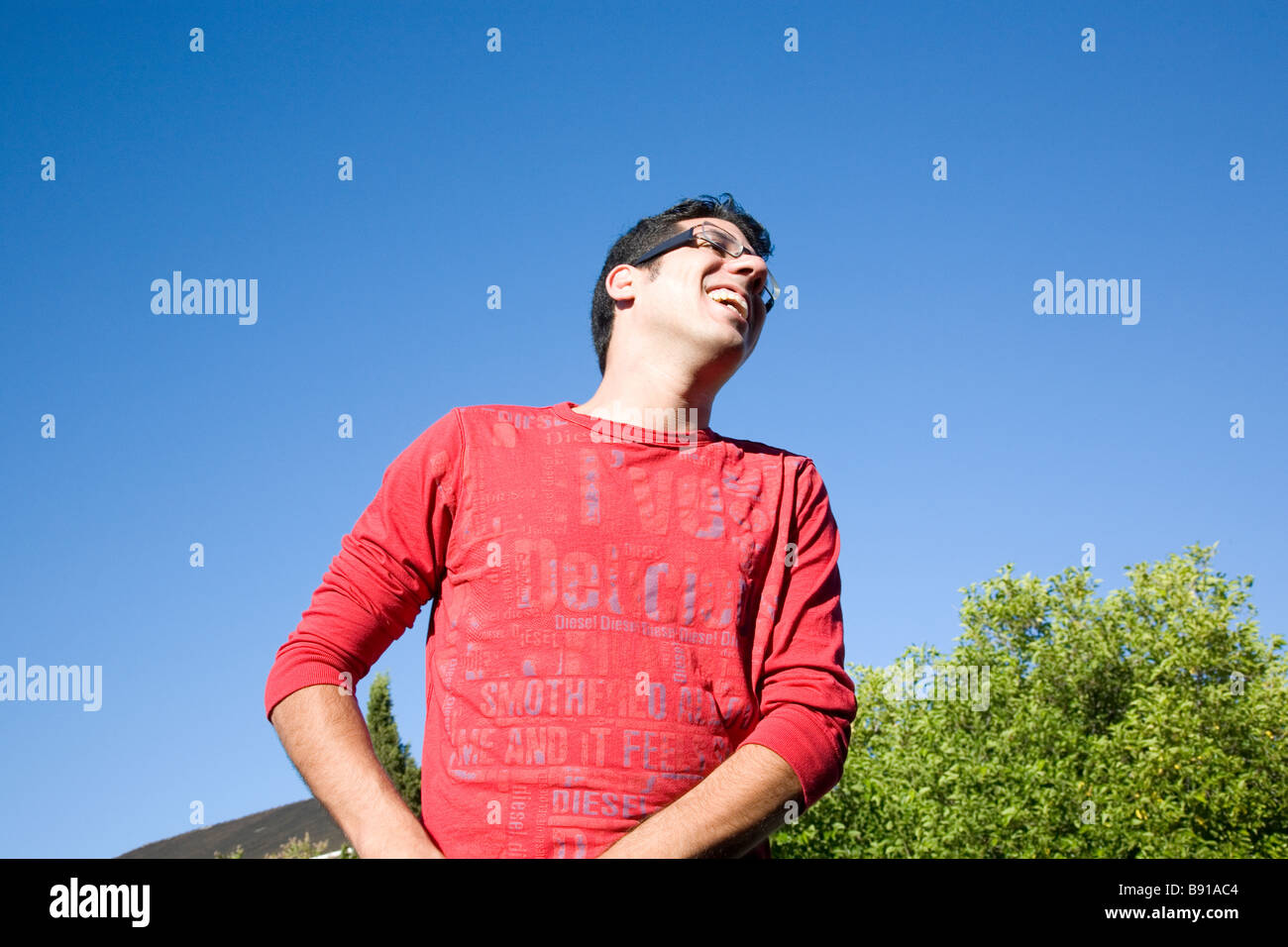 Geeky guy in Red Top against blue sky Stock Photo - Alamy