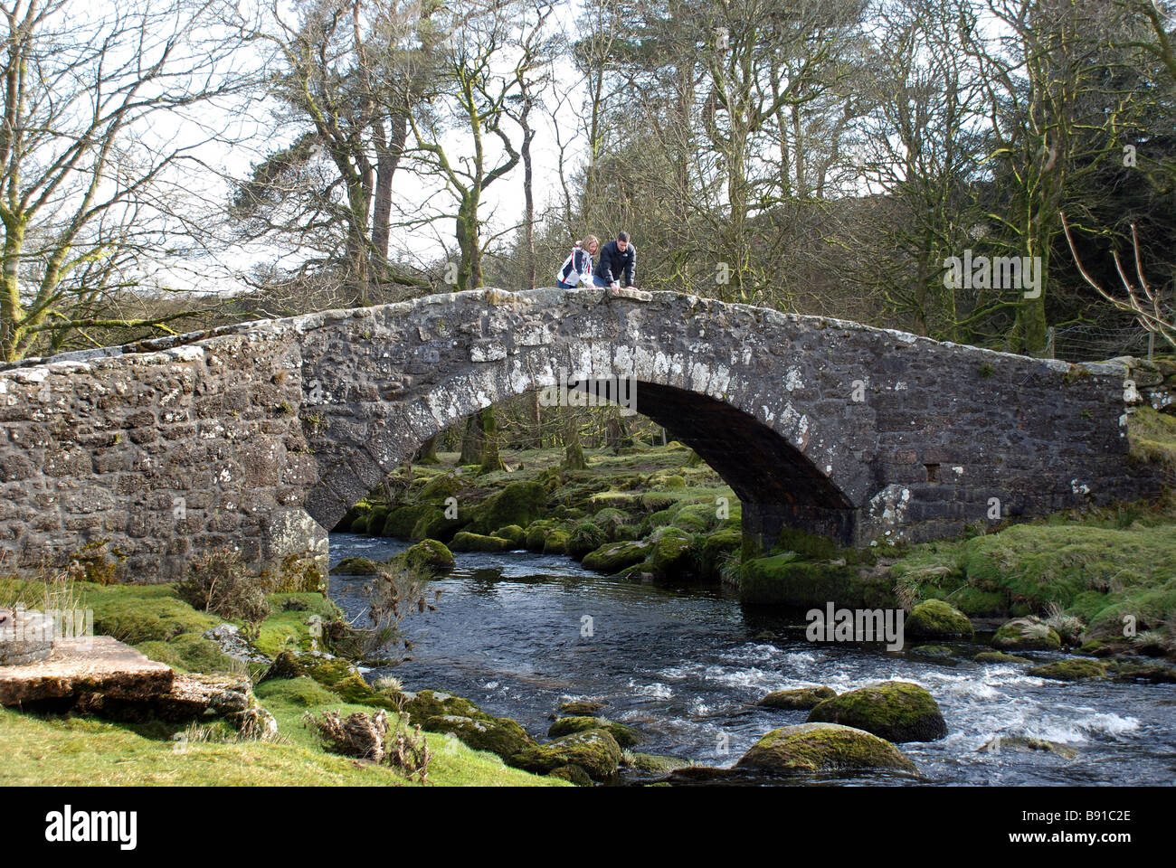 Young couple look over Dartmoor Bridge into West Dart river,color ...