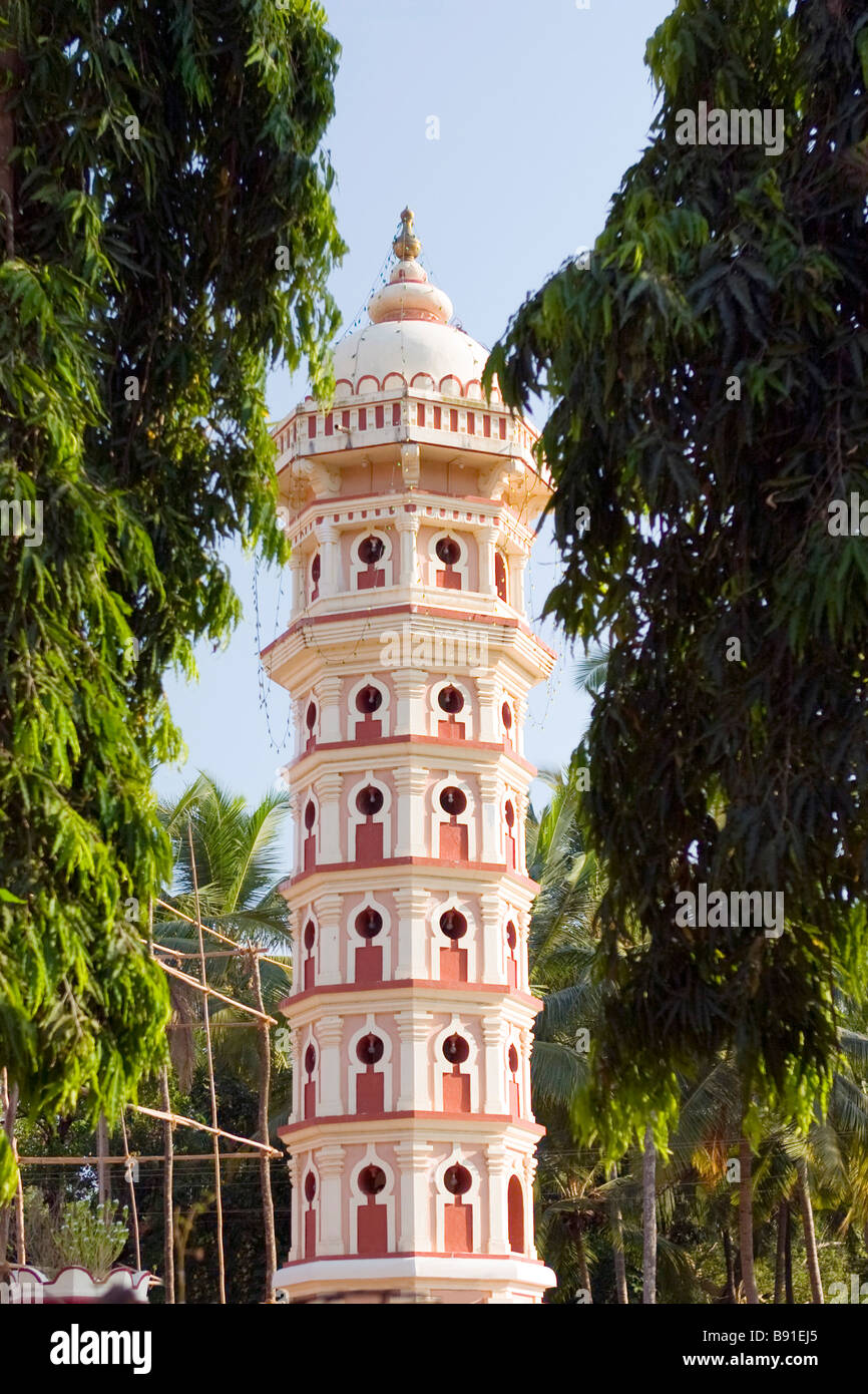 View on hindu temple lamp tower through trees Stock Photo - Alamy
