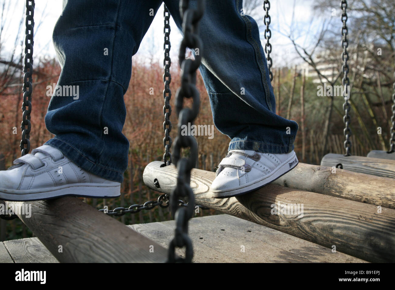 pair of legs with trainers crossing a hanging bridge Stock Photo - Alamy