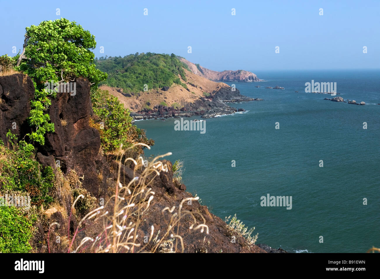 View on rocky cape and island in Indian Ocean, Goa, India Stock Photo ...
