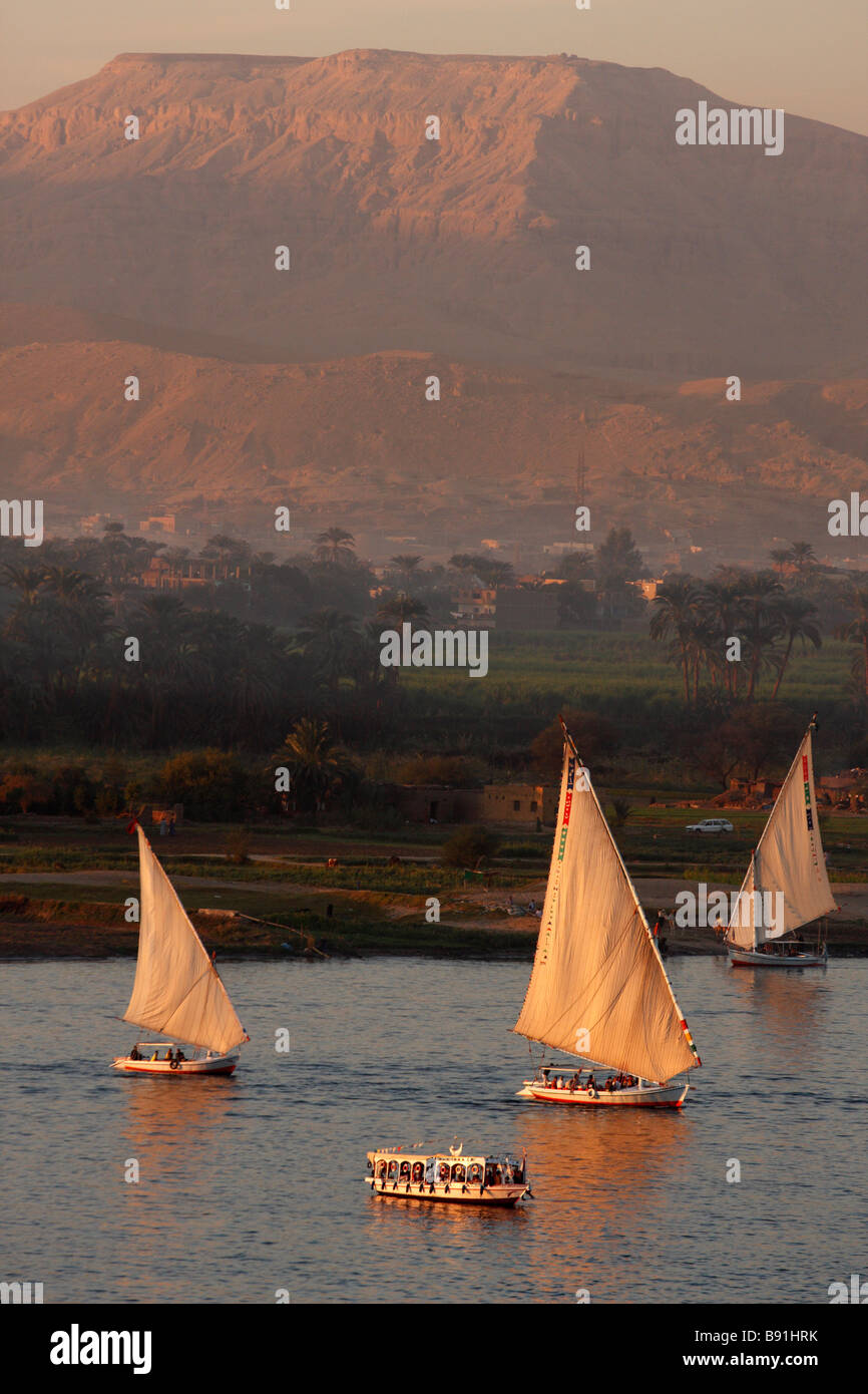 Traditional felucca boats sailing on [River Nile] at dusk, Luxor, Egypt ...