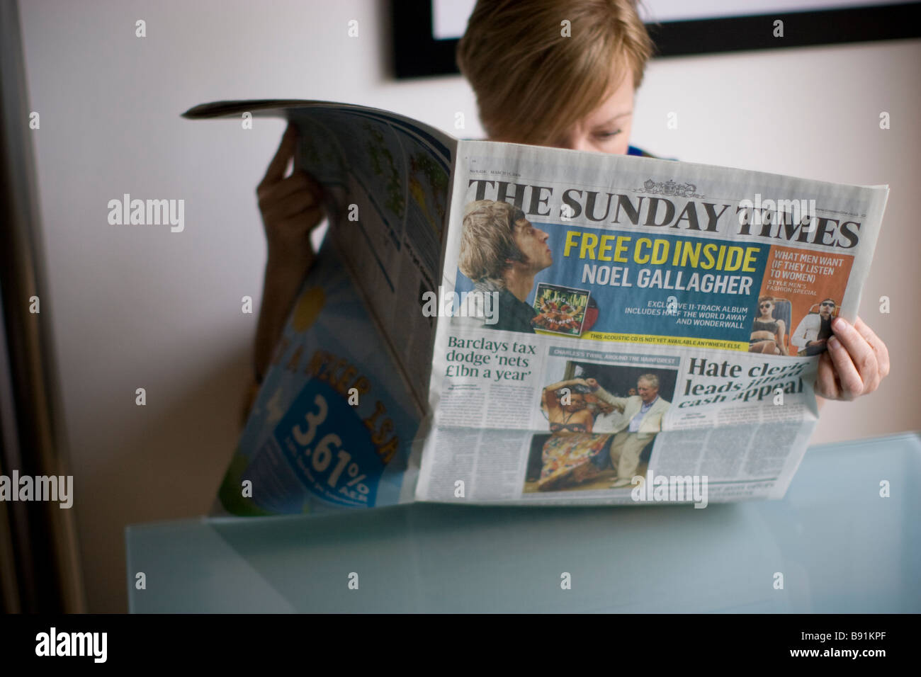 uk sunday newspaper reader The sunday times with free CD skyline Stock ...