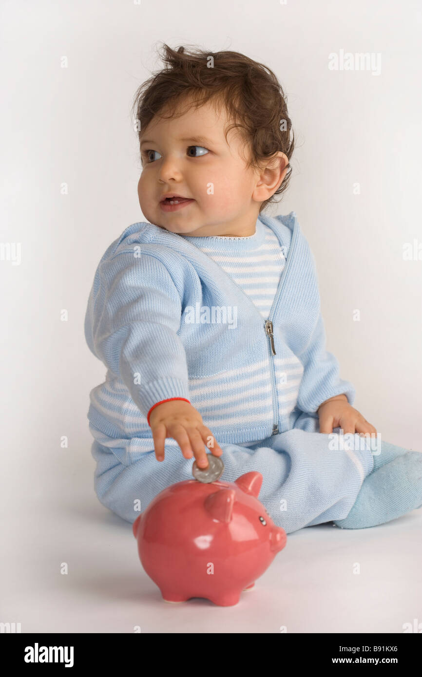baby boy putting a coin into a piggy bank Stock Photo - Alamy