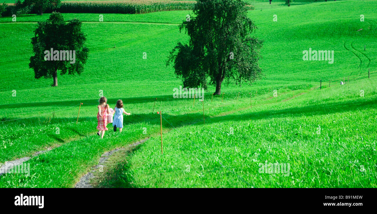 two little girl running on a path through the green Stock Photo - Alamy