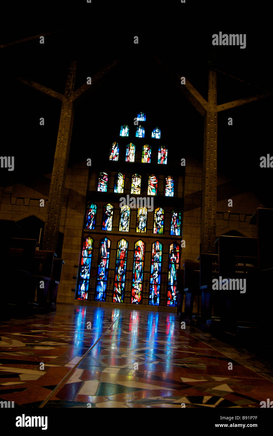 Upper church stained glass windows reflected on mosaic floor inside ...