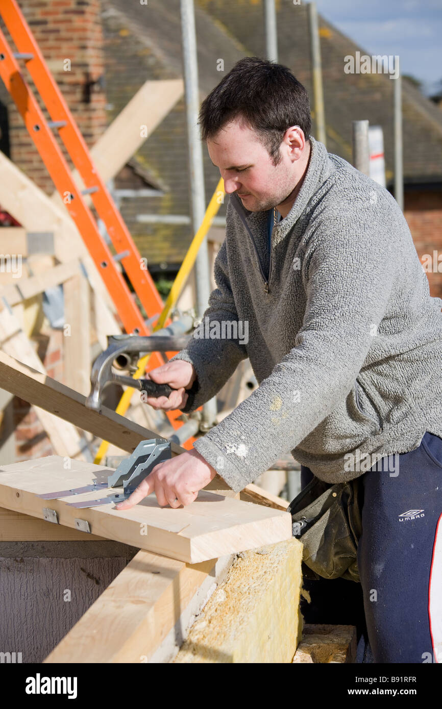 Nailing a mono- truss hanger to a joist infill Stock Photo - Alamy