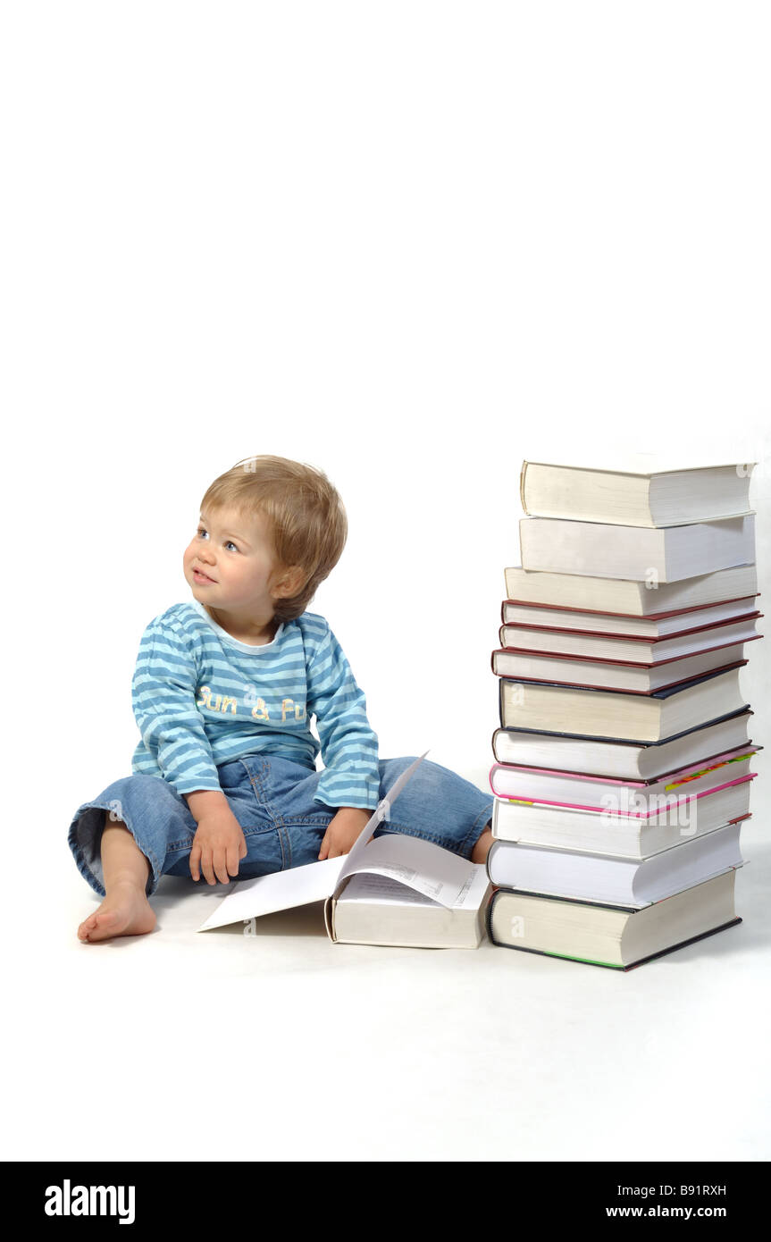 Small child with a pile of books Stock Photo - Alamy