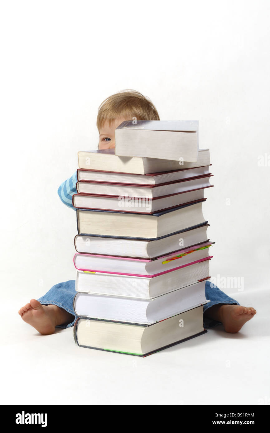Small child with a pile of books Stock Photo - Alamy