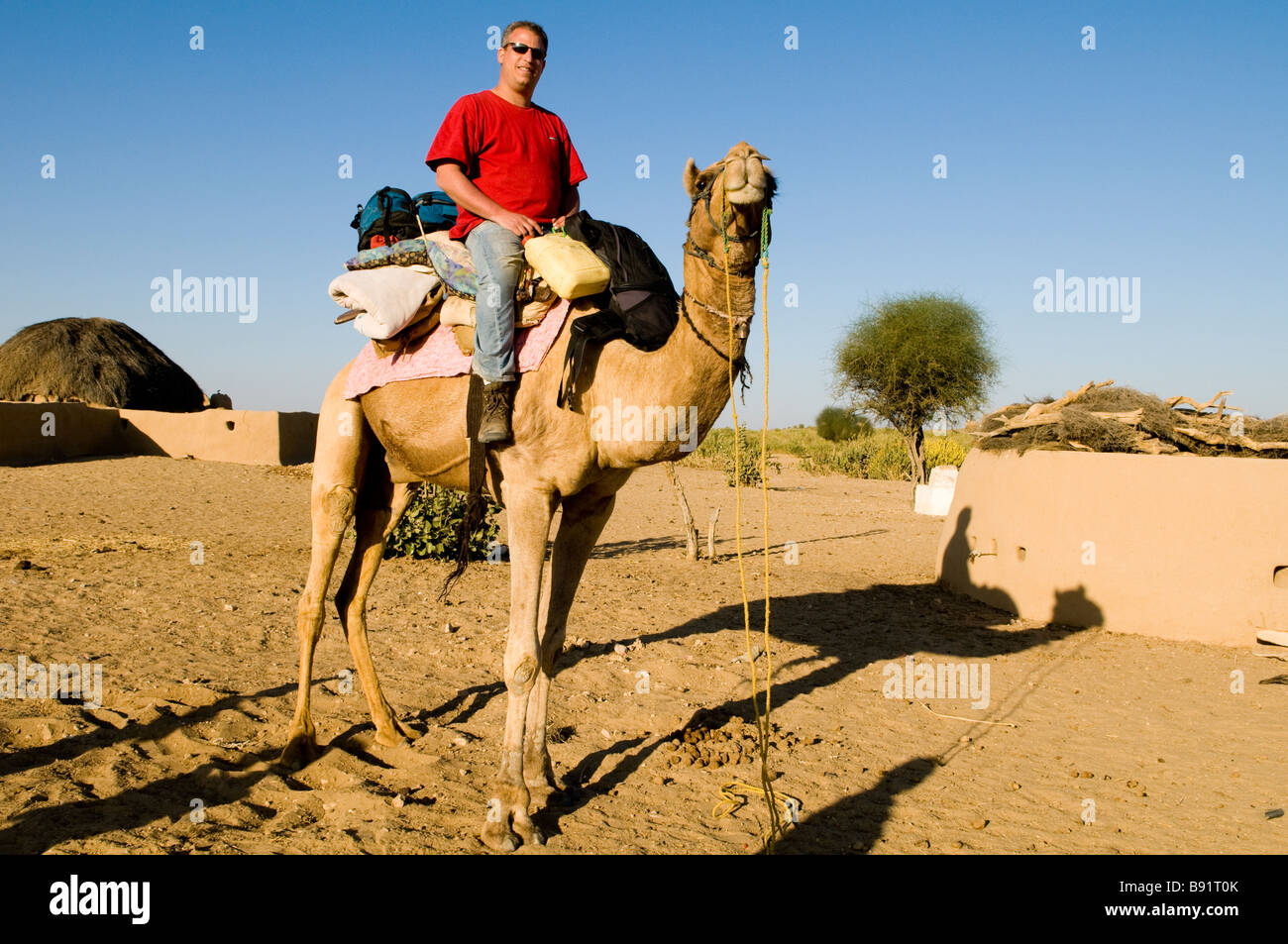 A foreign traveller riding his camel through the Indian desert Stock ...