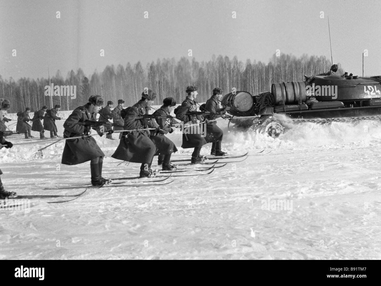 A tank pulling infantrymen on skis during military exercises in the ...