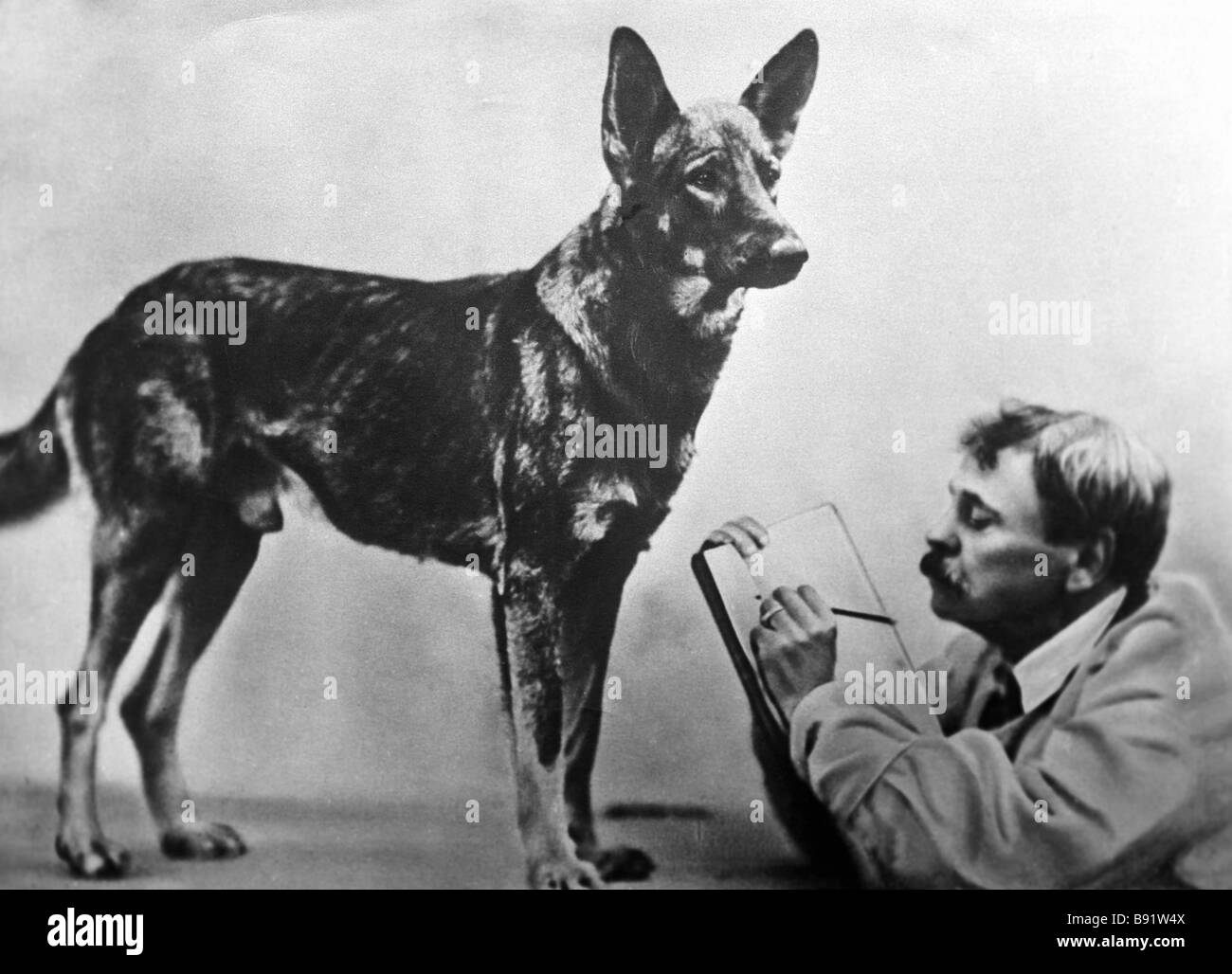 Merited Artist of the Russian SFSR Vladimir Durov watching a dog during ...