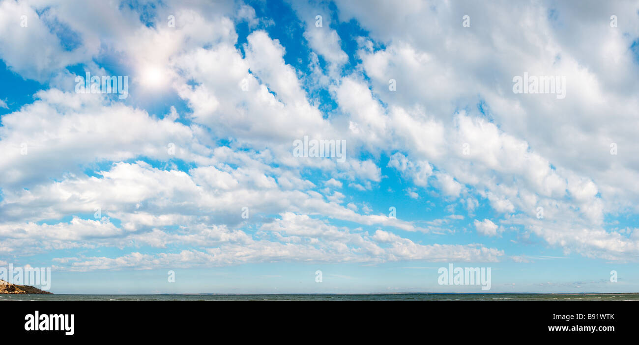 Blue height sky above the sea surface with sun and clouds. Four shots ...