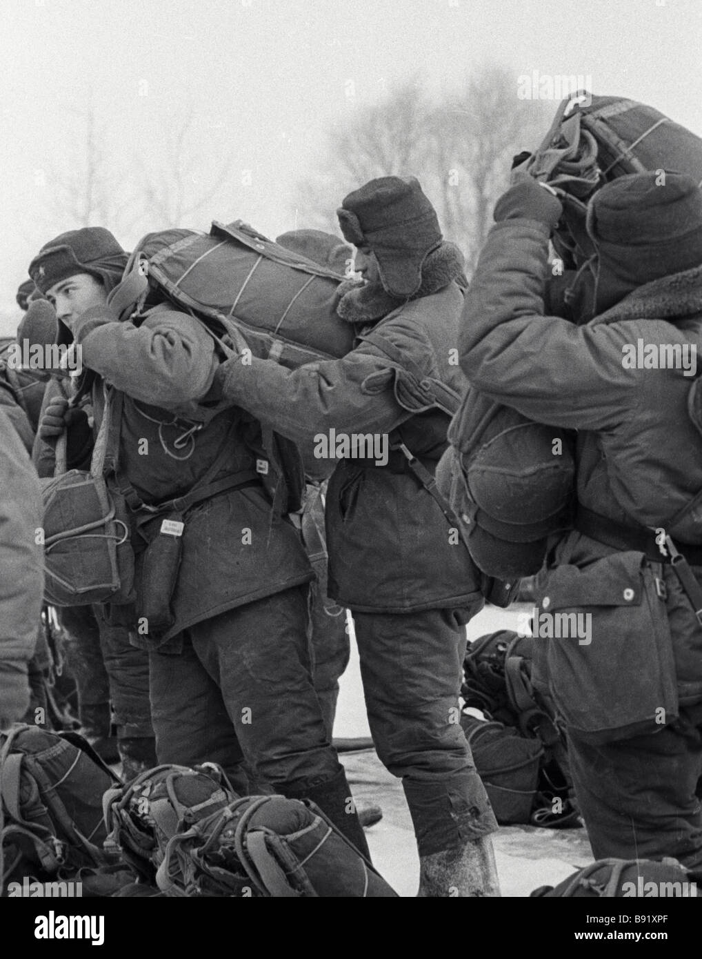 Commando squad commander helps a young soldier to put on parachute ...