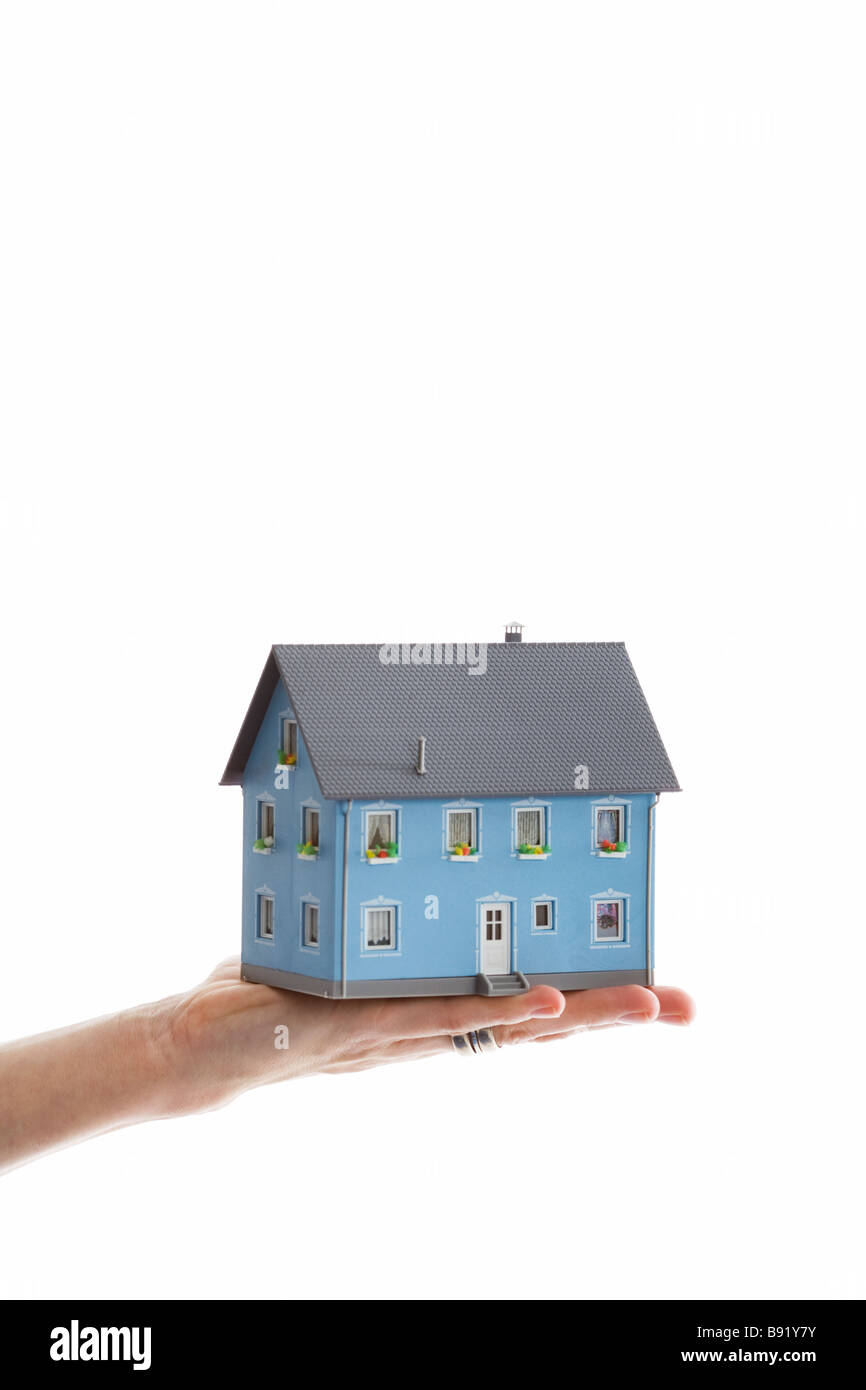 A hand holding a miniature house Stock Photo - Alamy