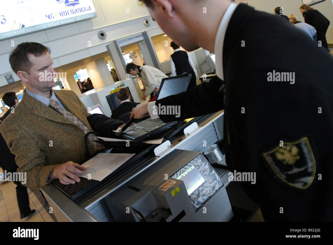 A security guard of Domodedovo Airport checking passengers portable ...