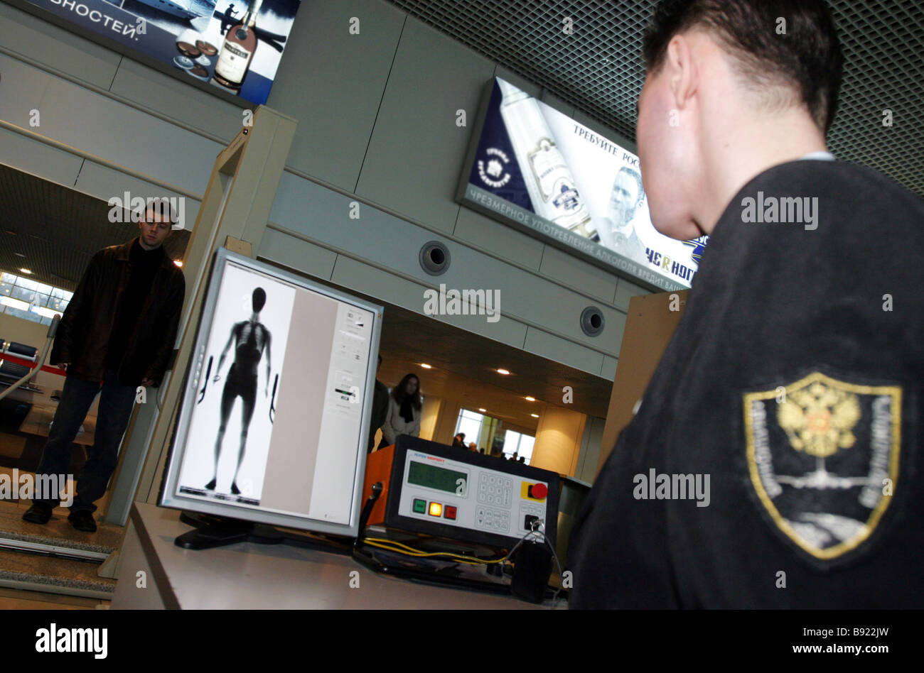 A security guard of Domodedovo Airport checking passengers with the ...