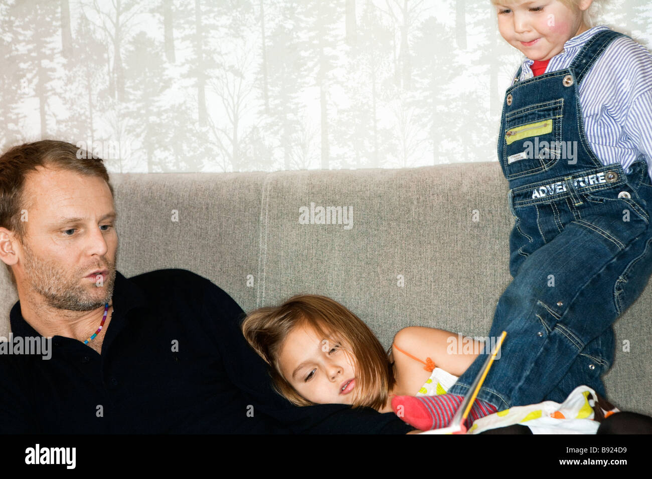 Father son and daughter reading a book Sweden Stock Photo - Alamy