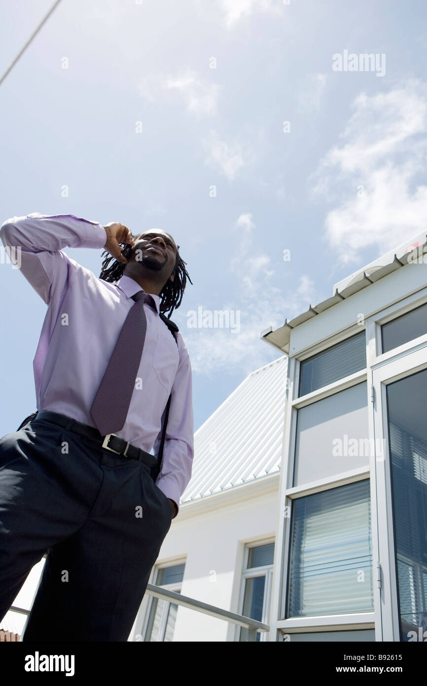 Low angle view of a businessman talking on his mobile phone Cape Town ...