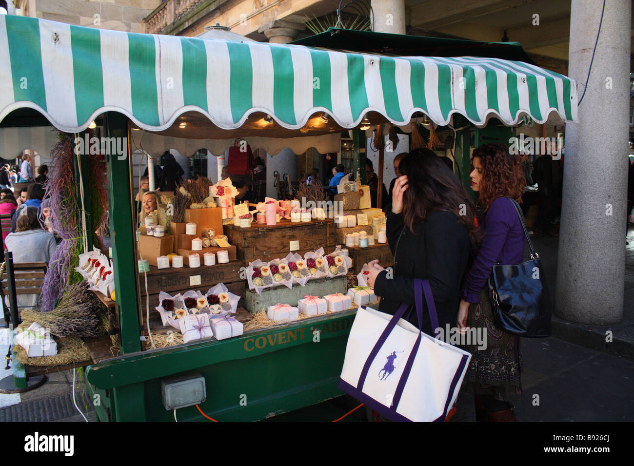 Two ladies browse a market stall at Covent Garden Stock Photo - Alamy