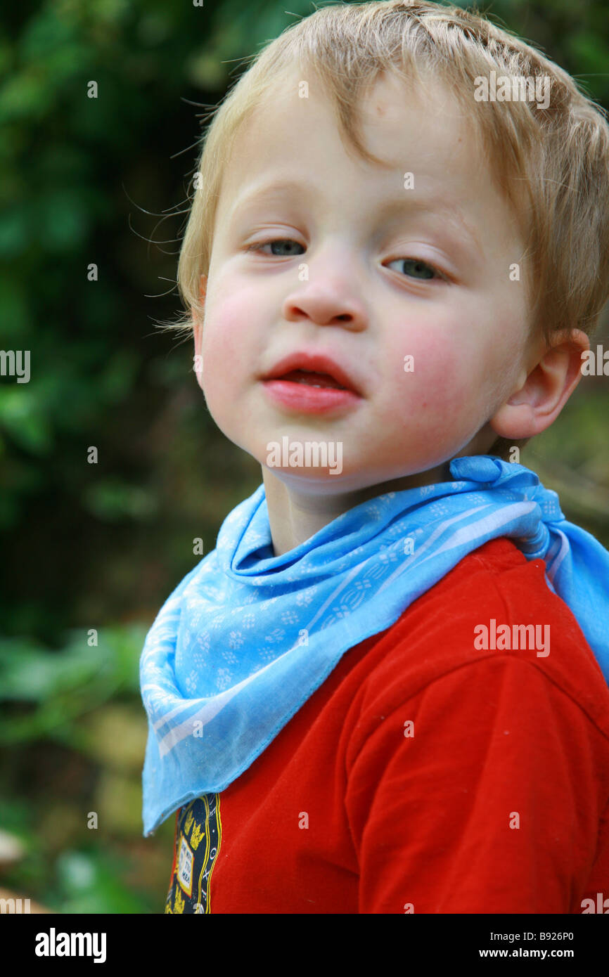 little boy looks cheeky with red t-shirt and blue scarf Stock Photo - Alamy