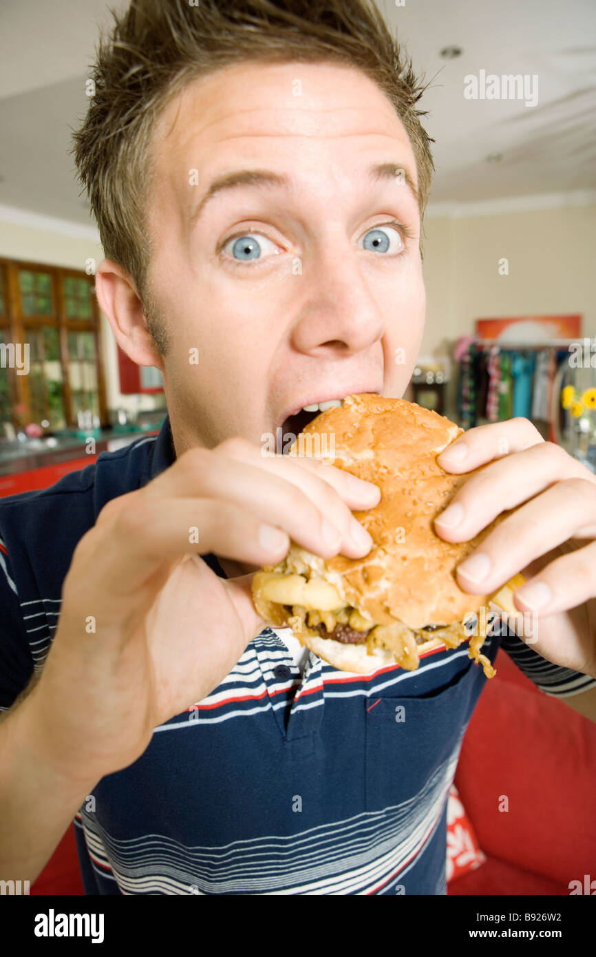 South African teen culture Young man taking a bite of a burger Stock ...