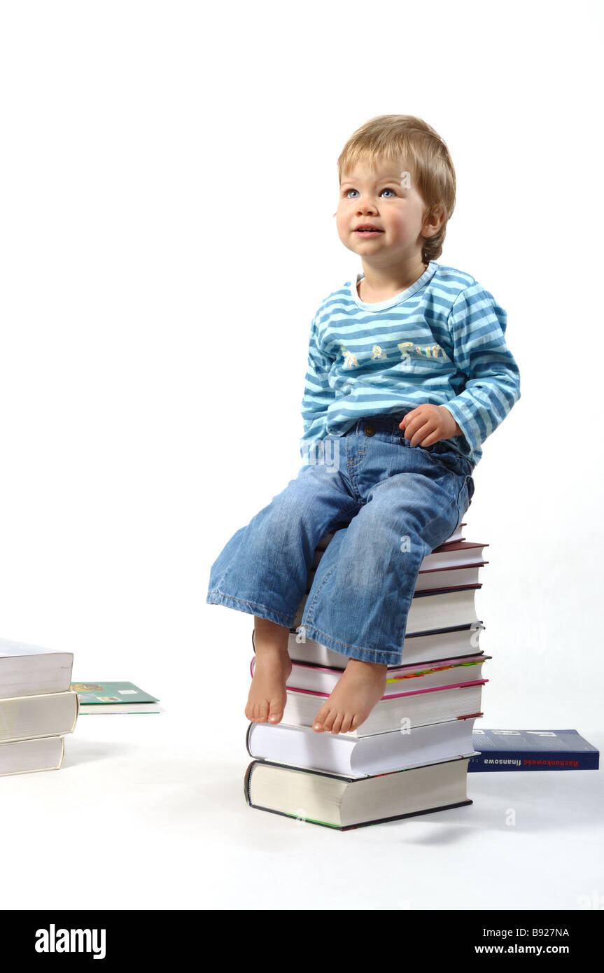 Small child with a pile of books Stock Photo - Alamy