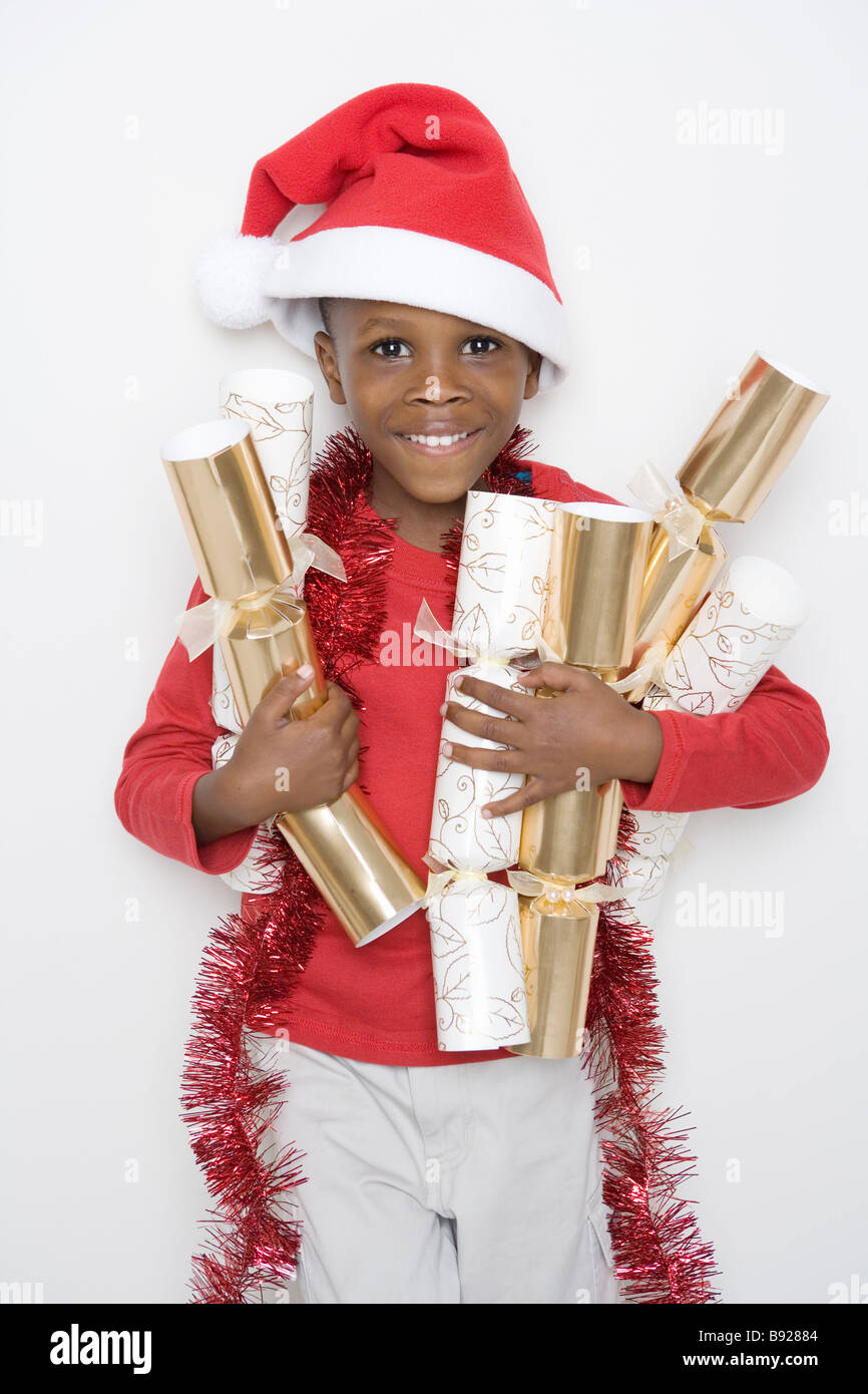 Boy with Christmas accessories holding onto a bunch of Christmas ...