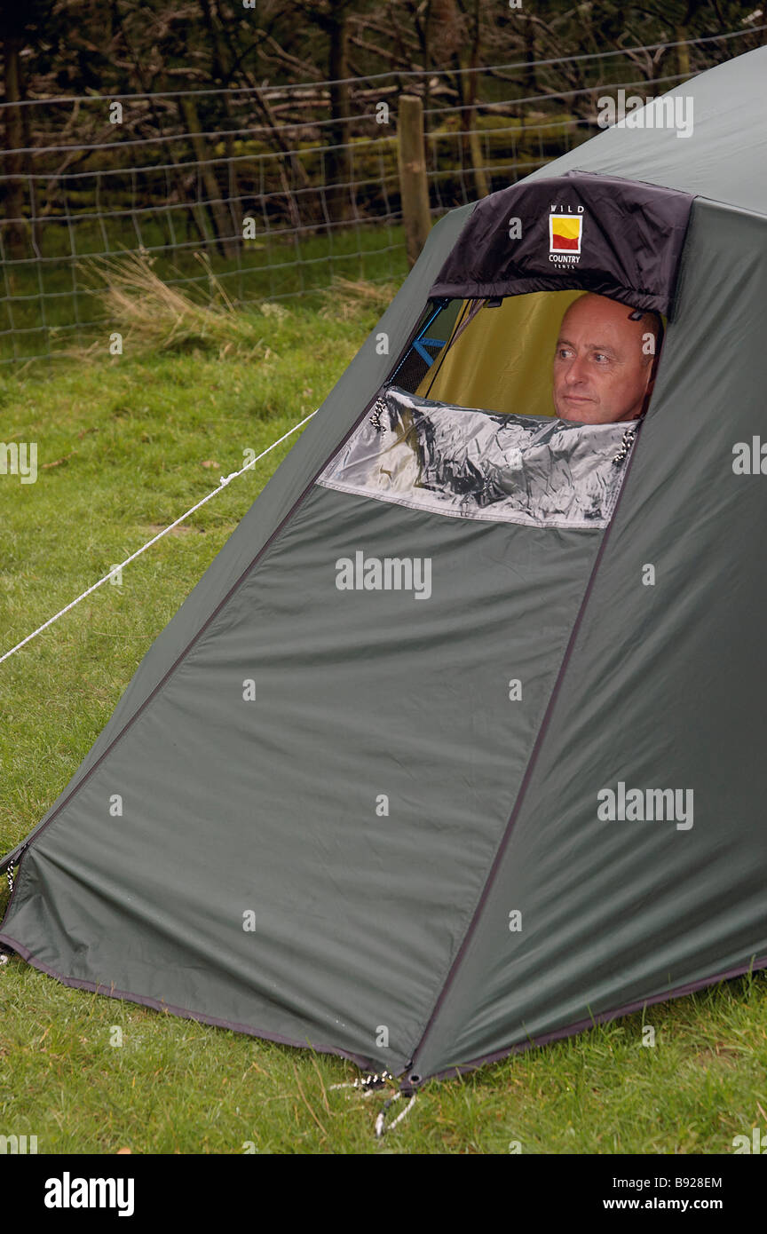 A man looking out of a tent Stock Photo - Alamy