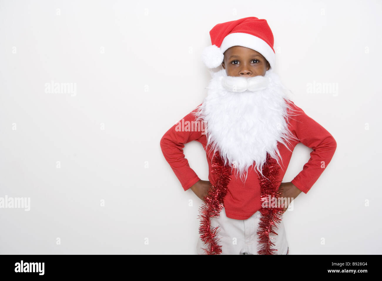 Boy dressed up like Father Christmas with a hat on his head and a fake ...