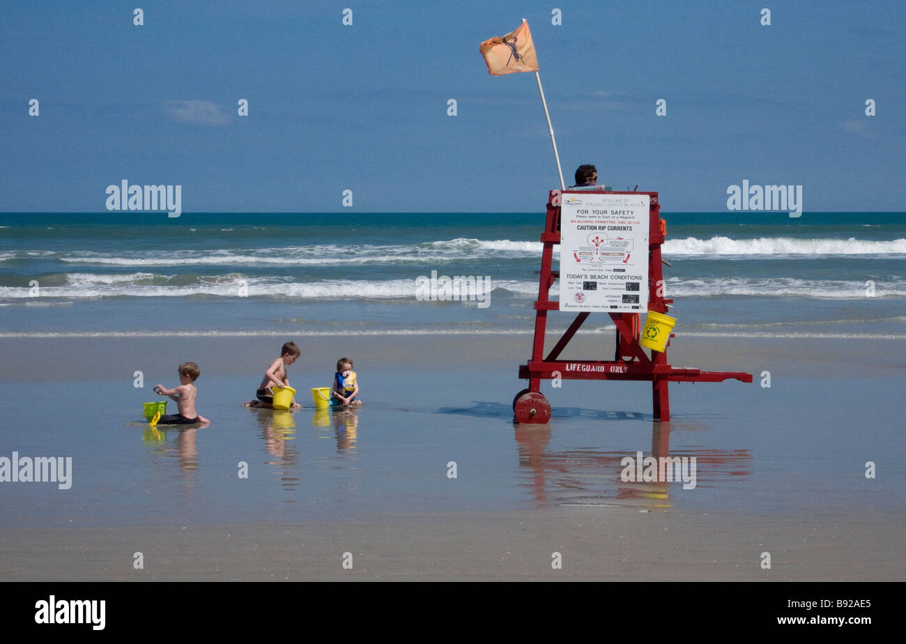 Children playing next to Lifeguard on New Smyrna Beach Florida USA ...