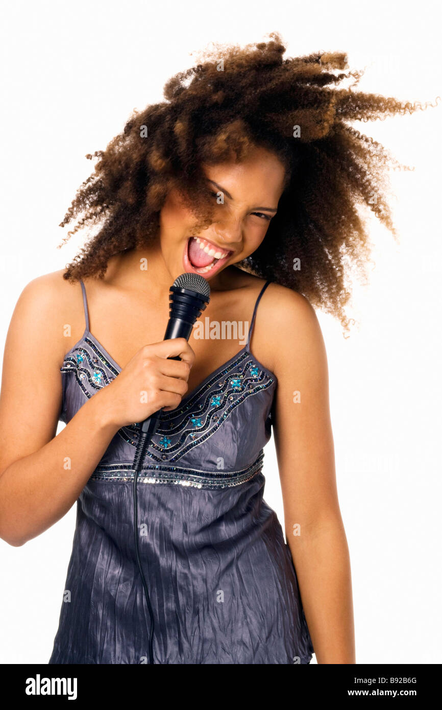 Studio shot of Young girl singing into microphone Stock Photo - Alamy