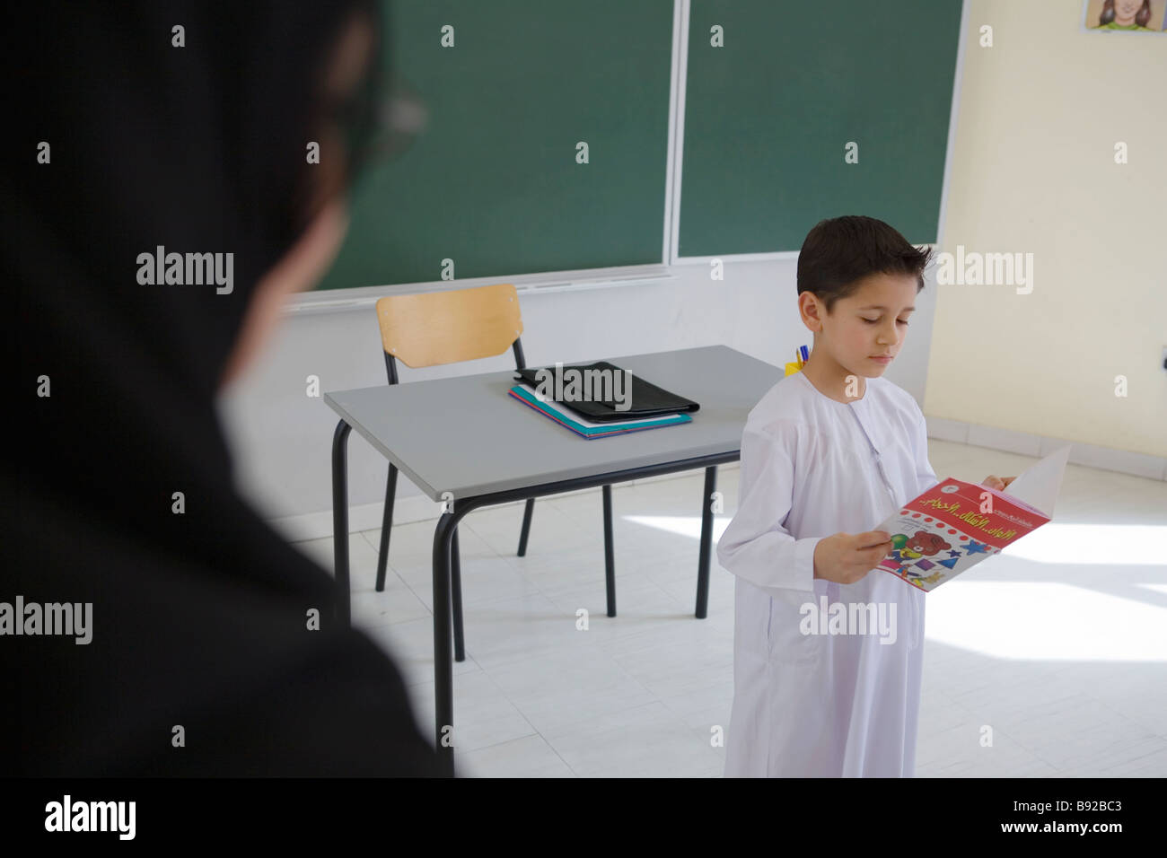 Young boy reading a school book in front of a class Dubai United Arab ...
