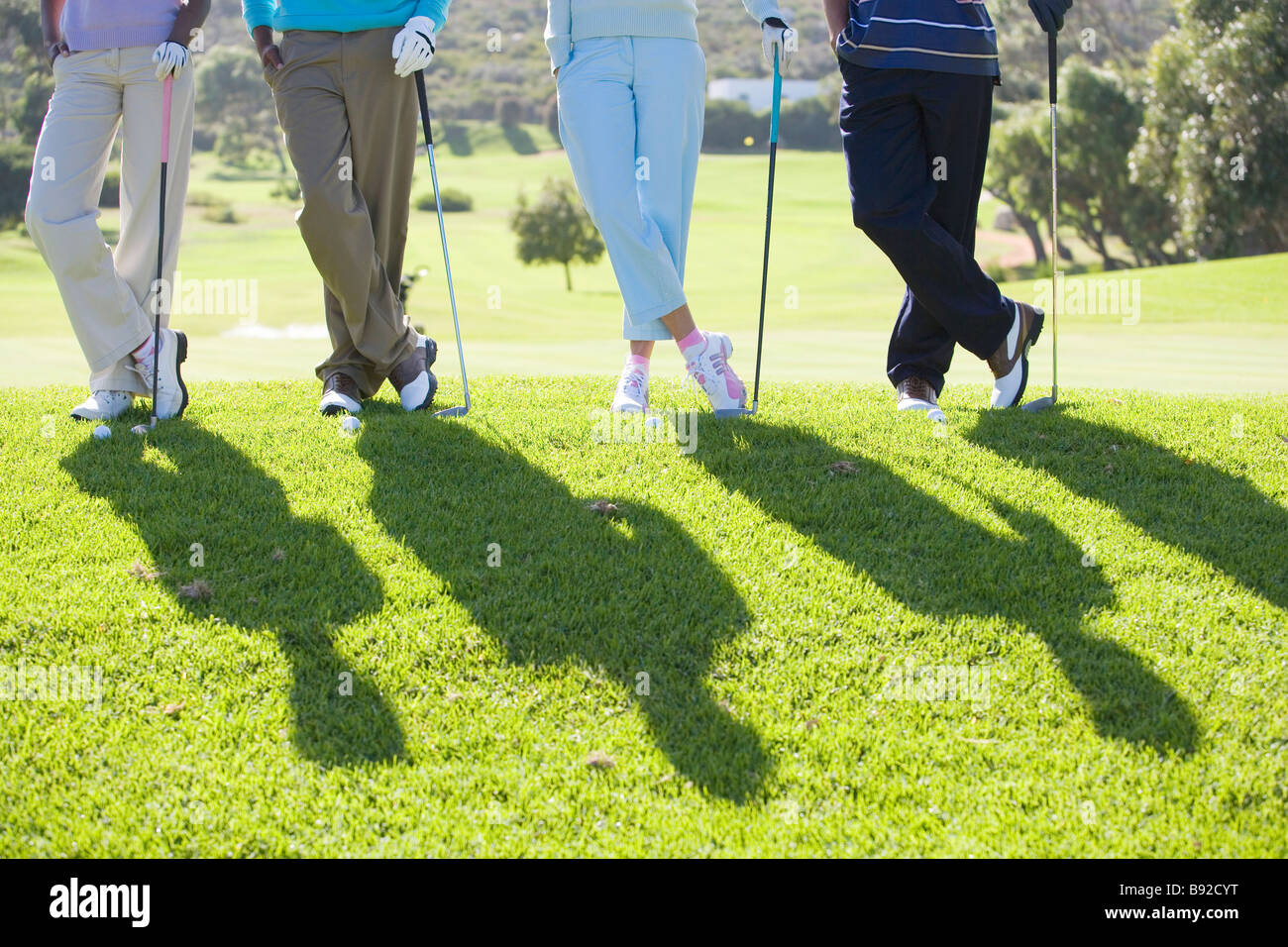 View of Four Golfers Standing Side by Side Waist Down Stock Photo - Alamy