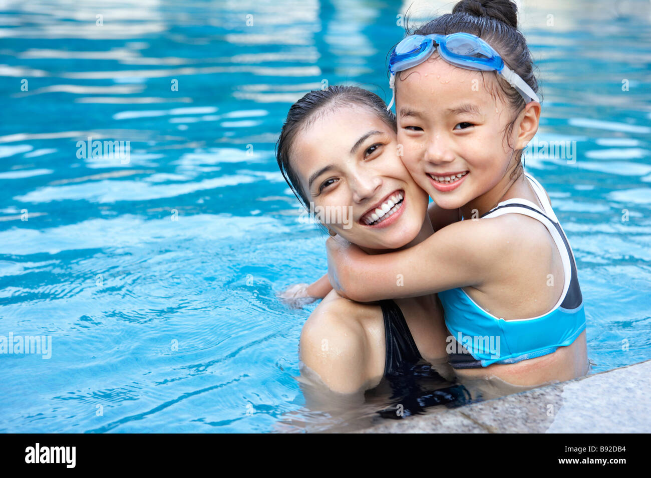 Mother daughter hugging swimming pool hi-res stock photography and ...