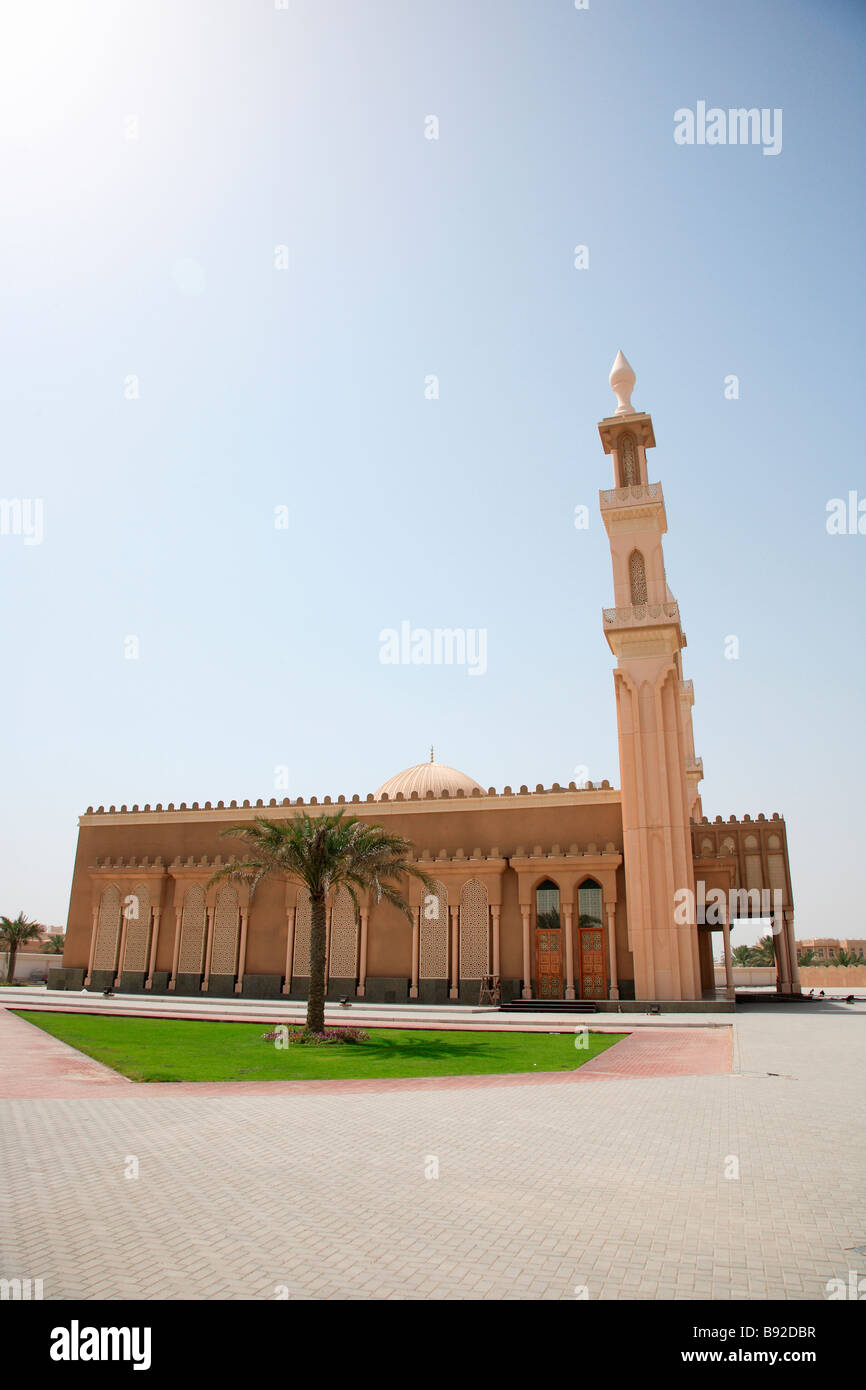 Side view of a brown and beige mosque against the blue sky Sharjah ...