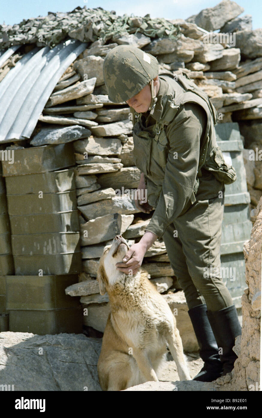 Soviet soldier internationalist stroking a dog at an outpost Stock ...