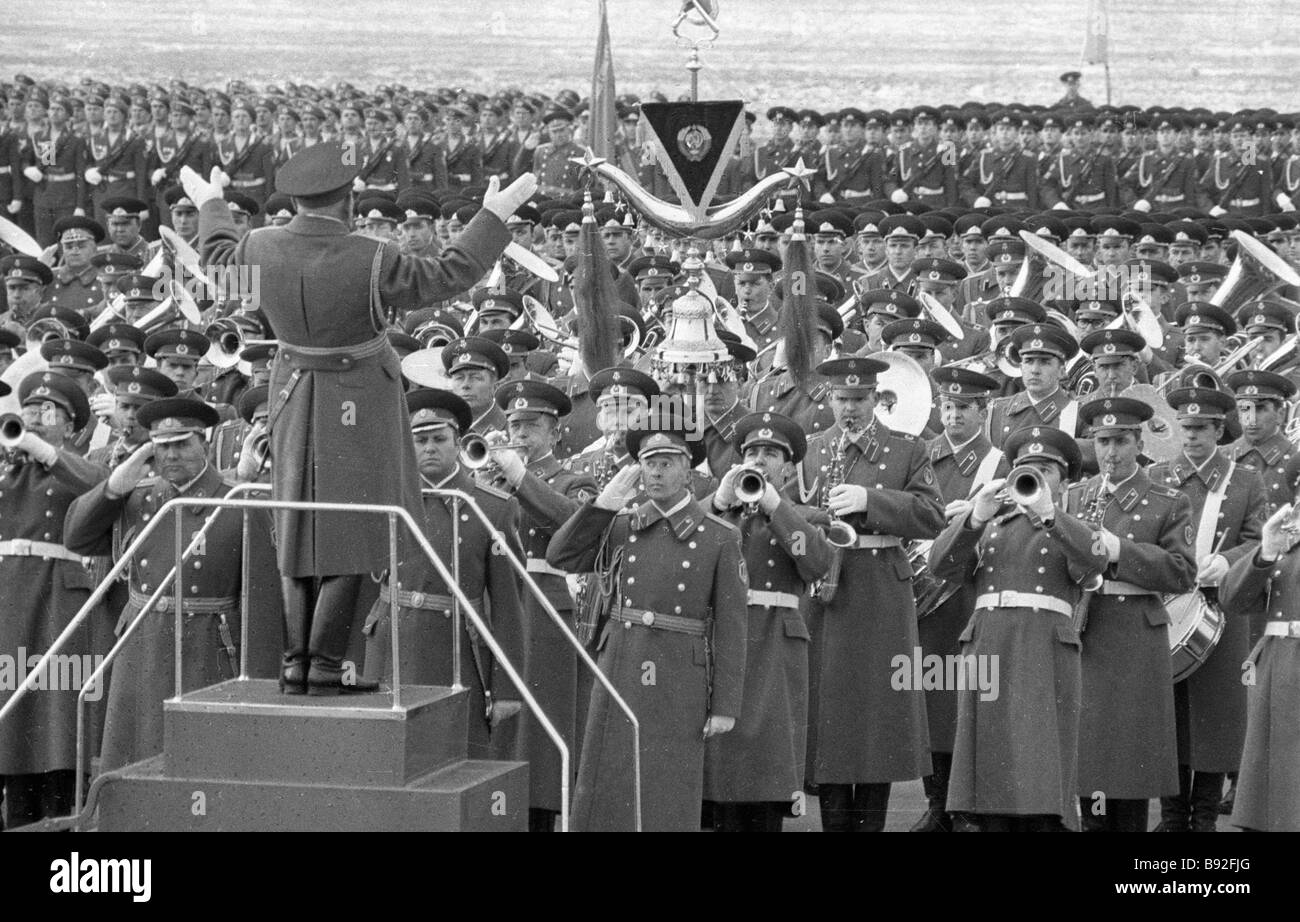 A conductor directing a joint military orchestra during a military ...