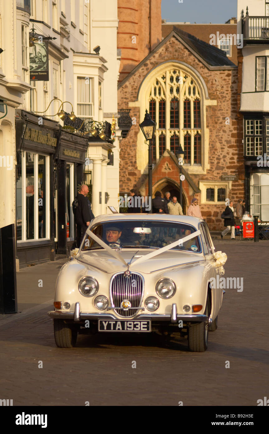 Classic jaguar wedding car driving along Cathedral Close in Exeter ...