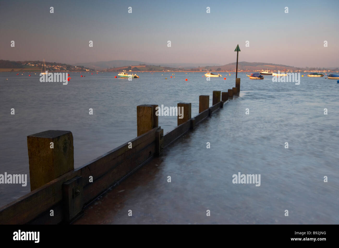 Dawn light illuminates fishing boats and yachts on the Exe estuary ...