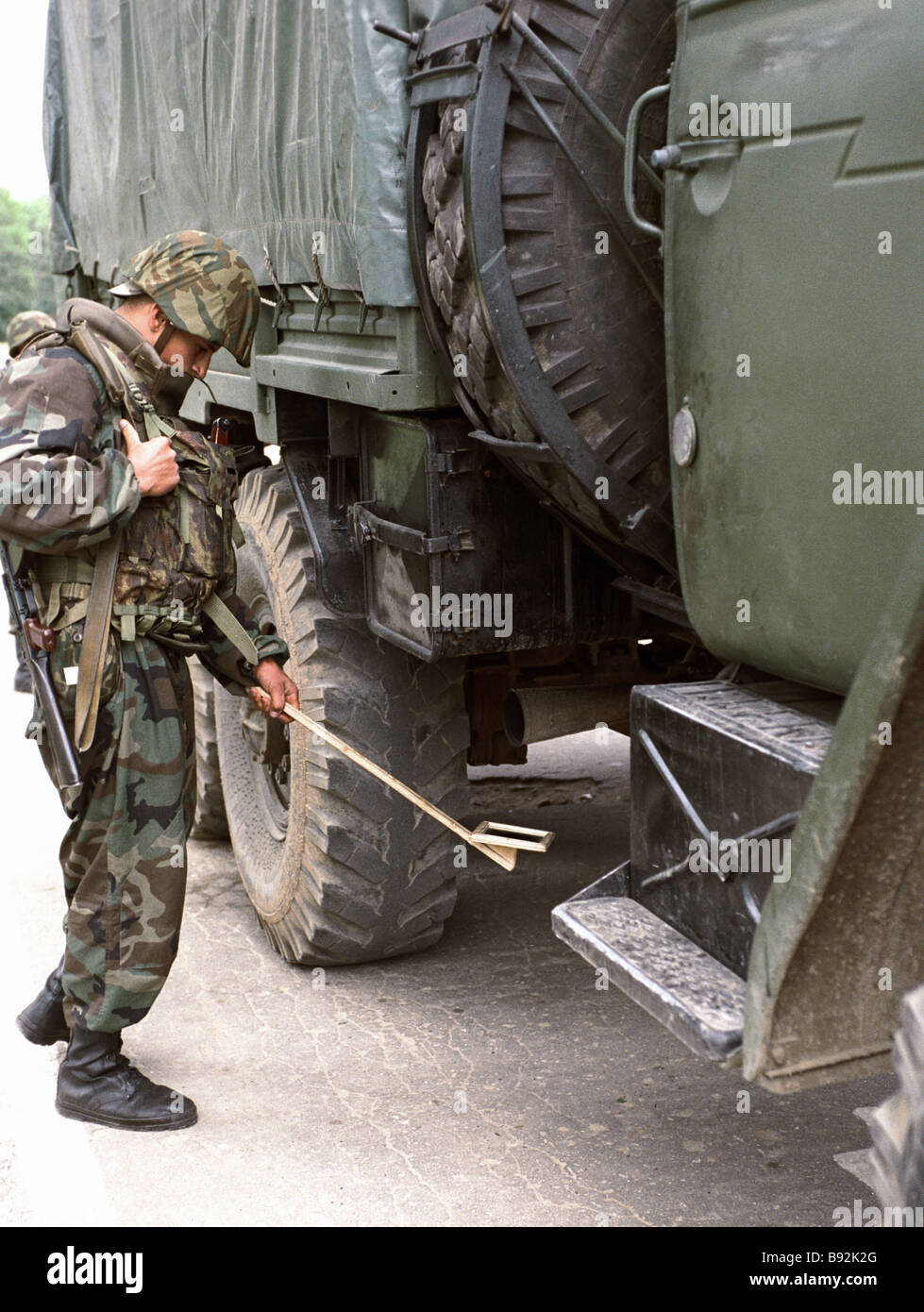 A soldier checking a motor vehicle at a crossing point during a joint ...