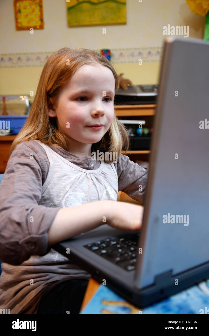 A girl, 7 years old, doing homework with school software in her child ...