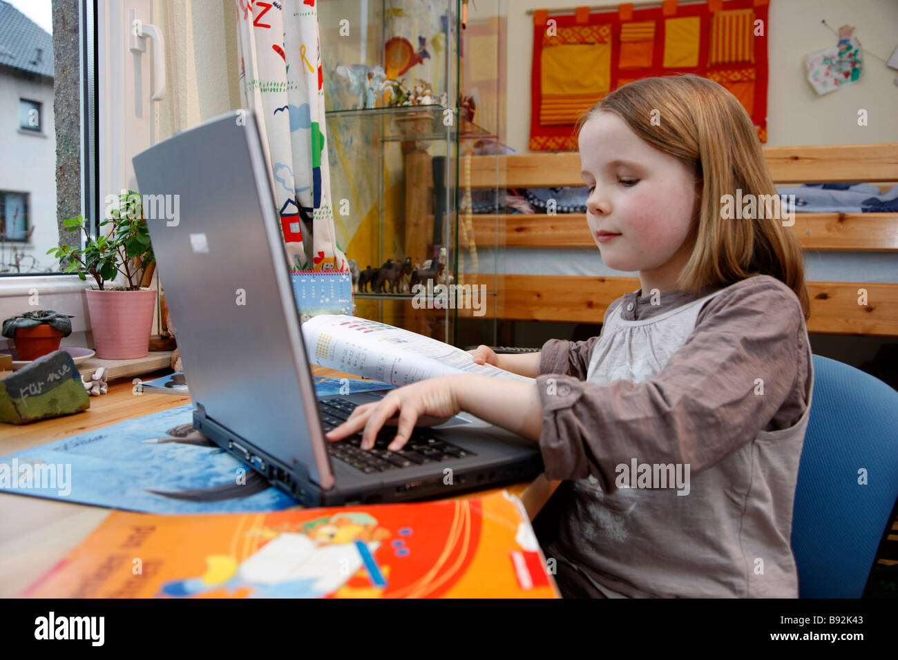 A girl, 7 years old, doing homework with school software in her child ...
