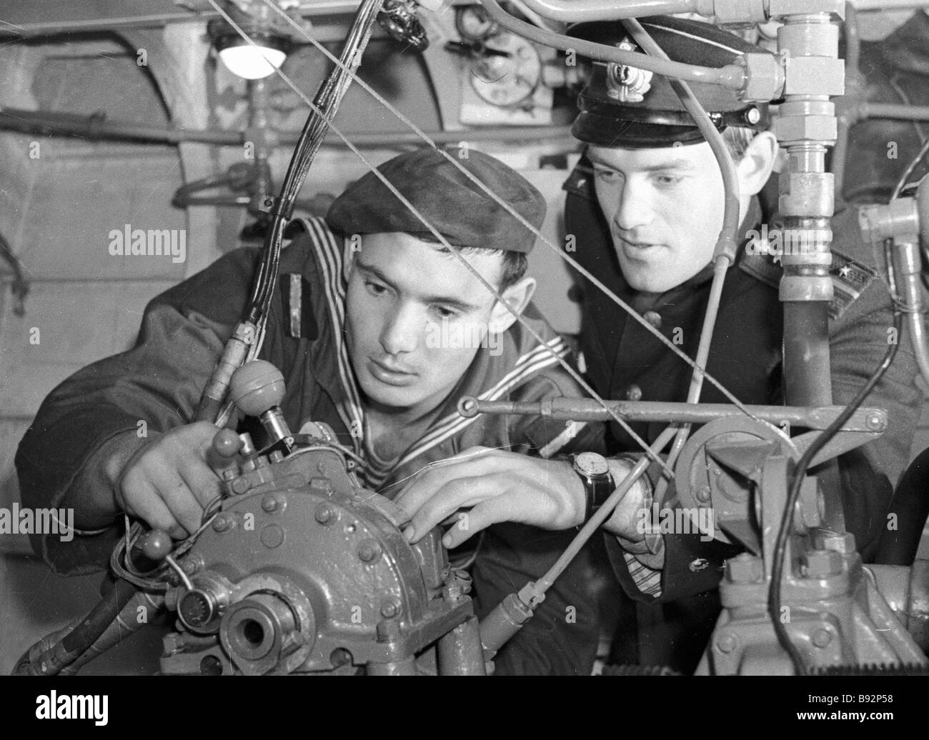 Junior Officer and Senior seaman inspecting a propulsion engine of a ...