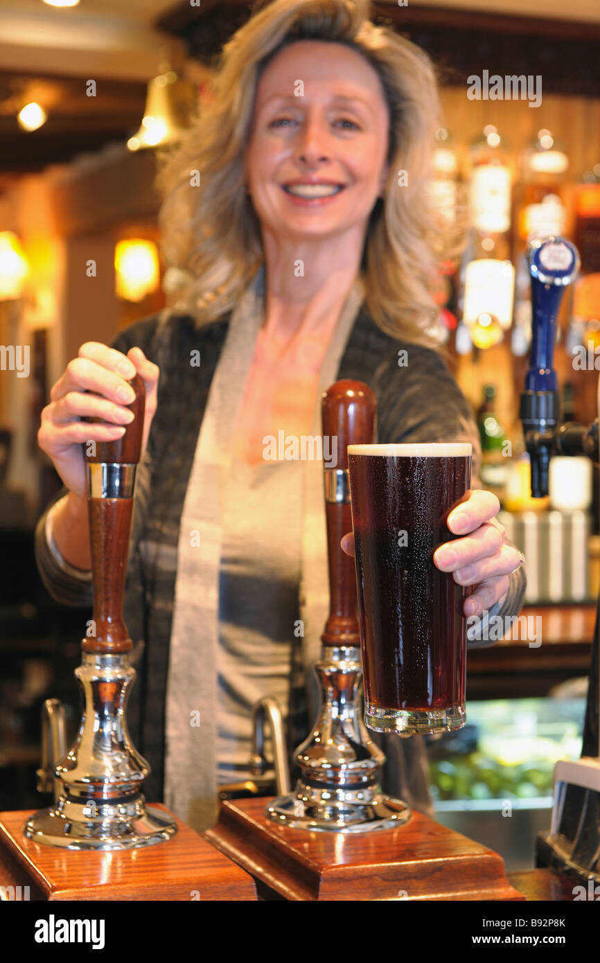 barmaid giving a customer a pint of beer Stock Photo - Alamy