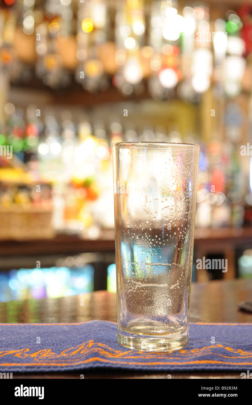 empty pint glass of beer sitting on bar in a pub Stock Photo - Alamy